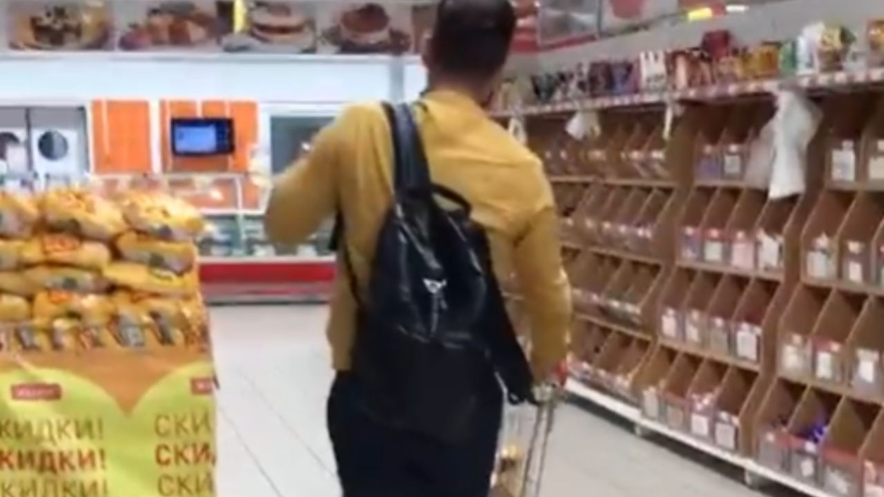 Boy tries riding a shopping cart and takes a fall in the aisle