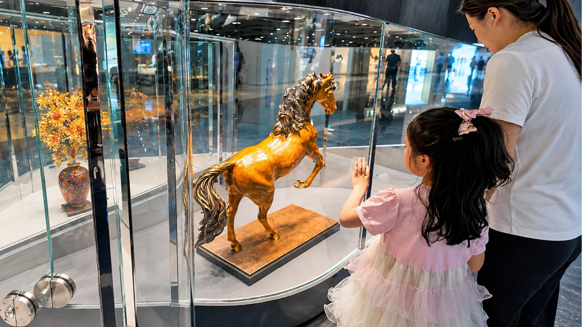 Visitors explore art installations along modern mall interior spaces