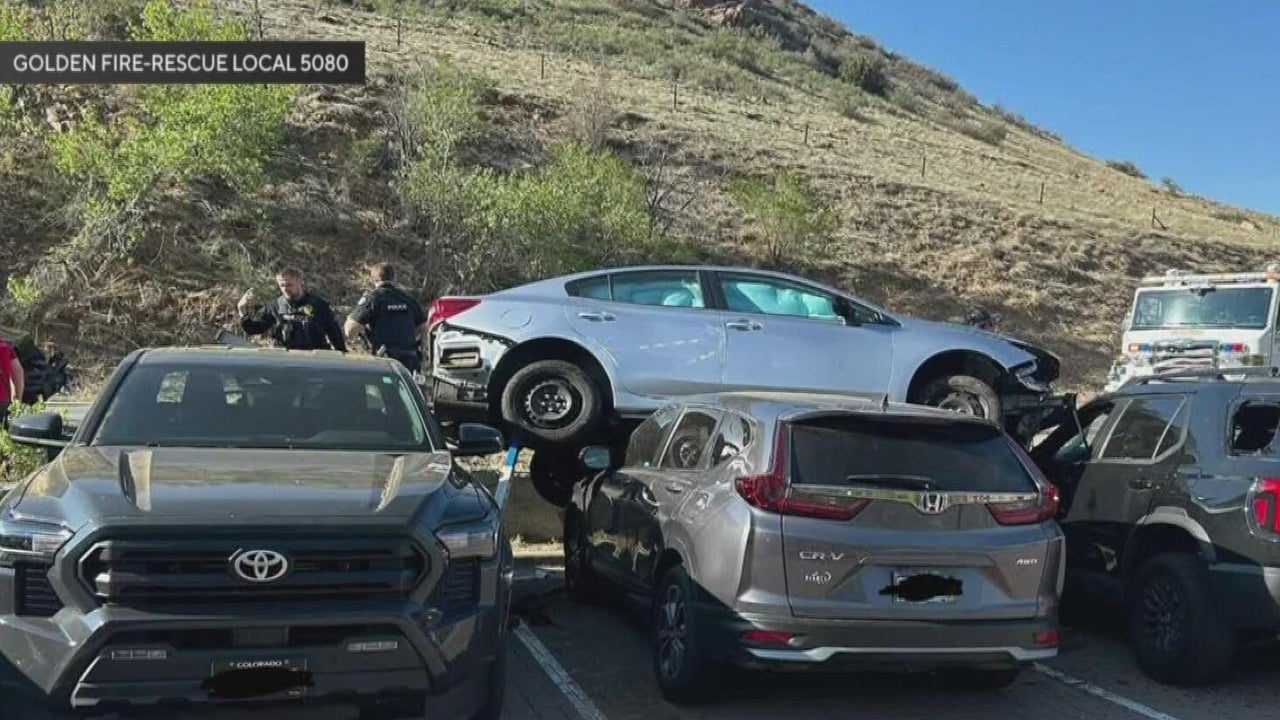 Golden police trying to learn how car ends up on top of three other cars