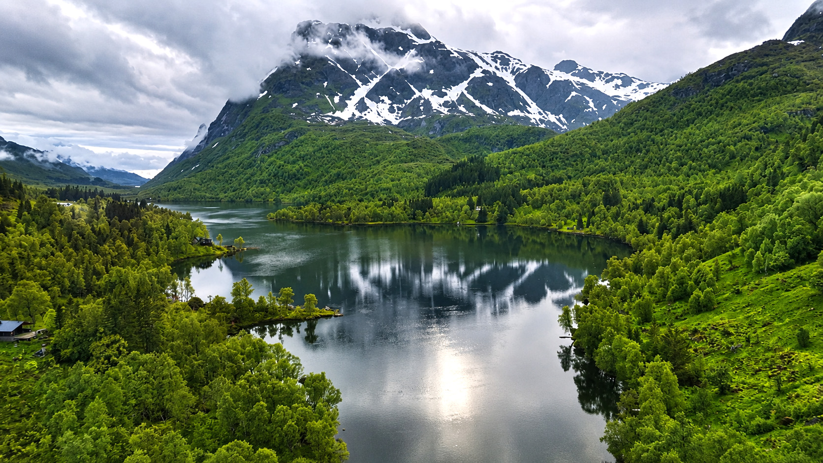A mirror like mountain lake reflecting snow covered peaks