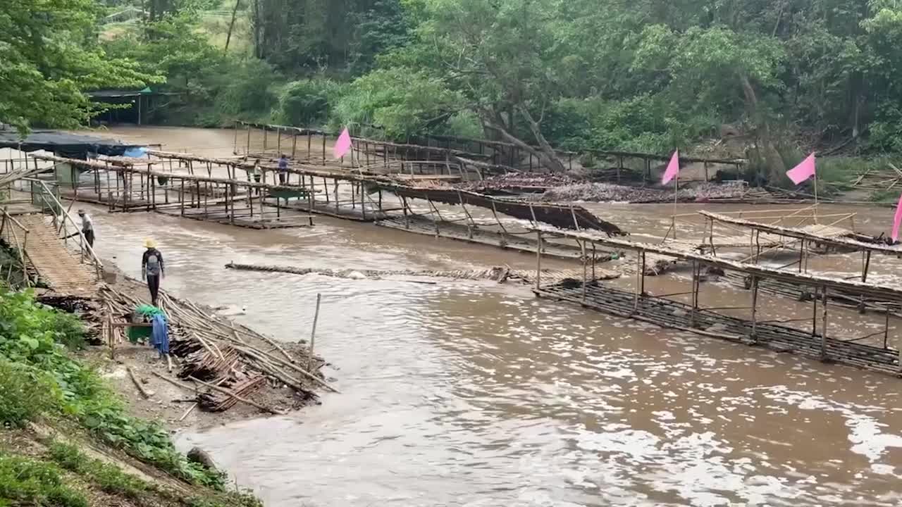 Raging floodwaters destroy riverside bamboo platforms