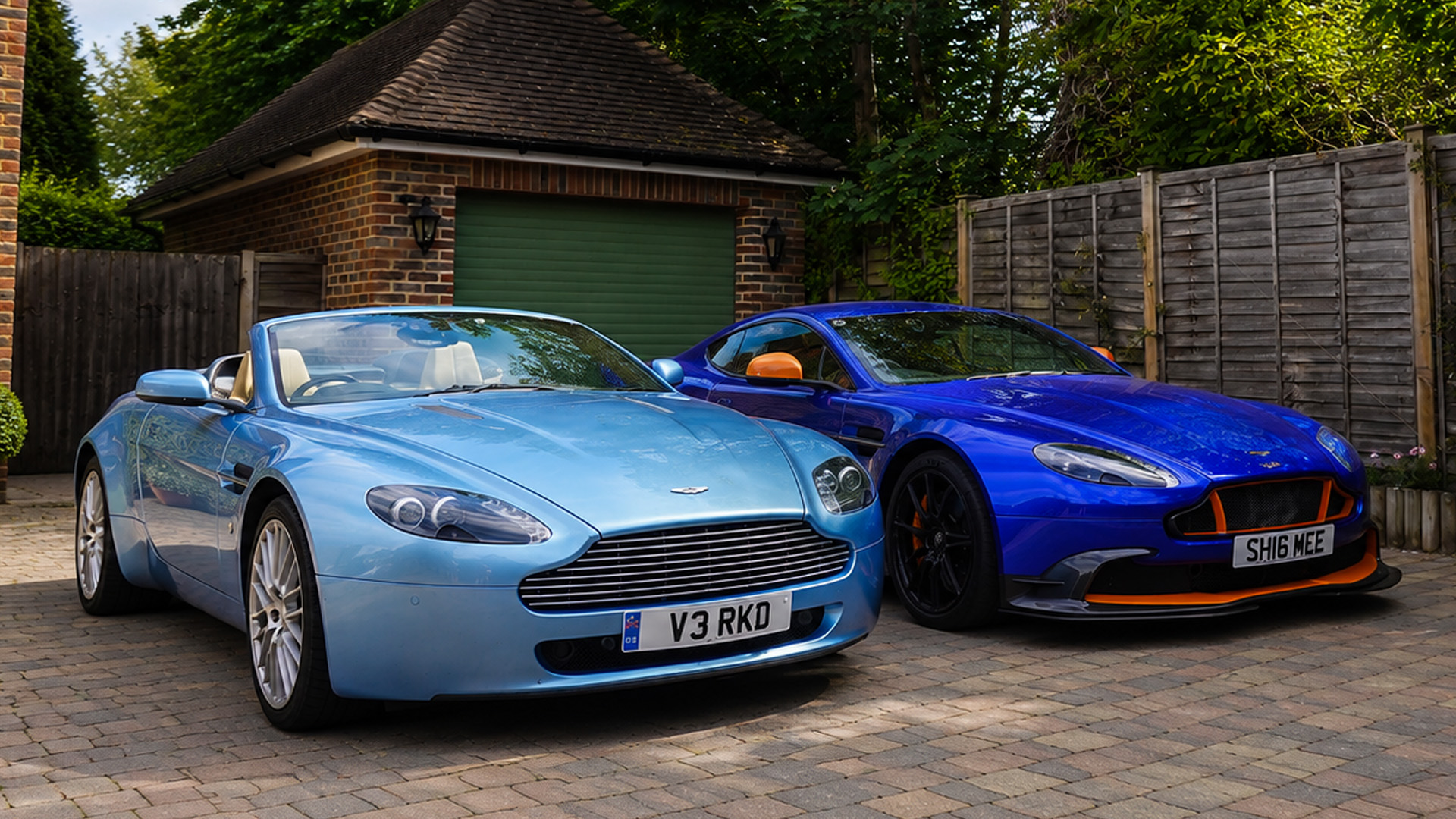 Light blue Aston Martin Vantage Roadster parked beside Vantage GT8
