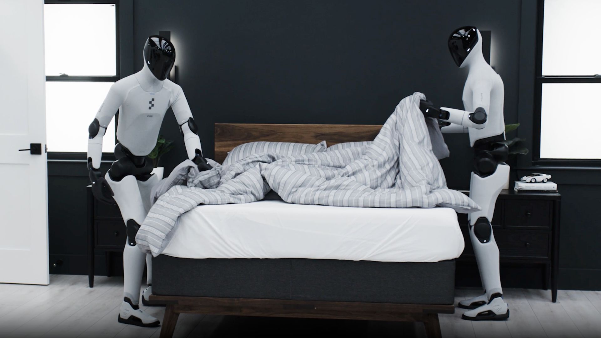 Two humanoid robots clean a bedroom, organizing, hanging clothes, and ...