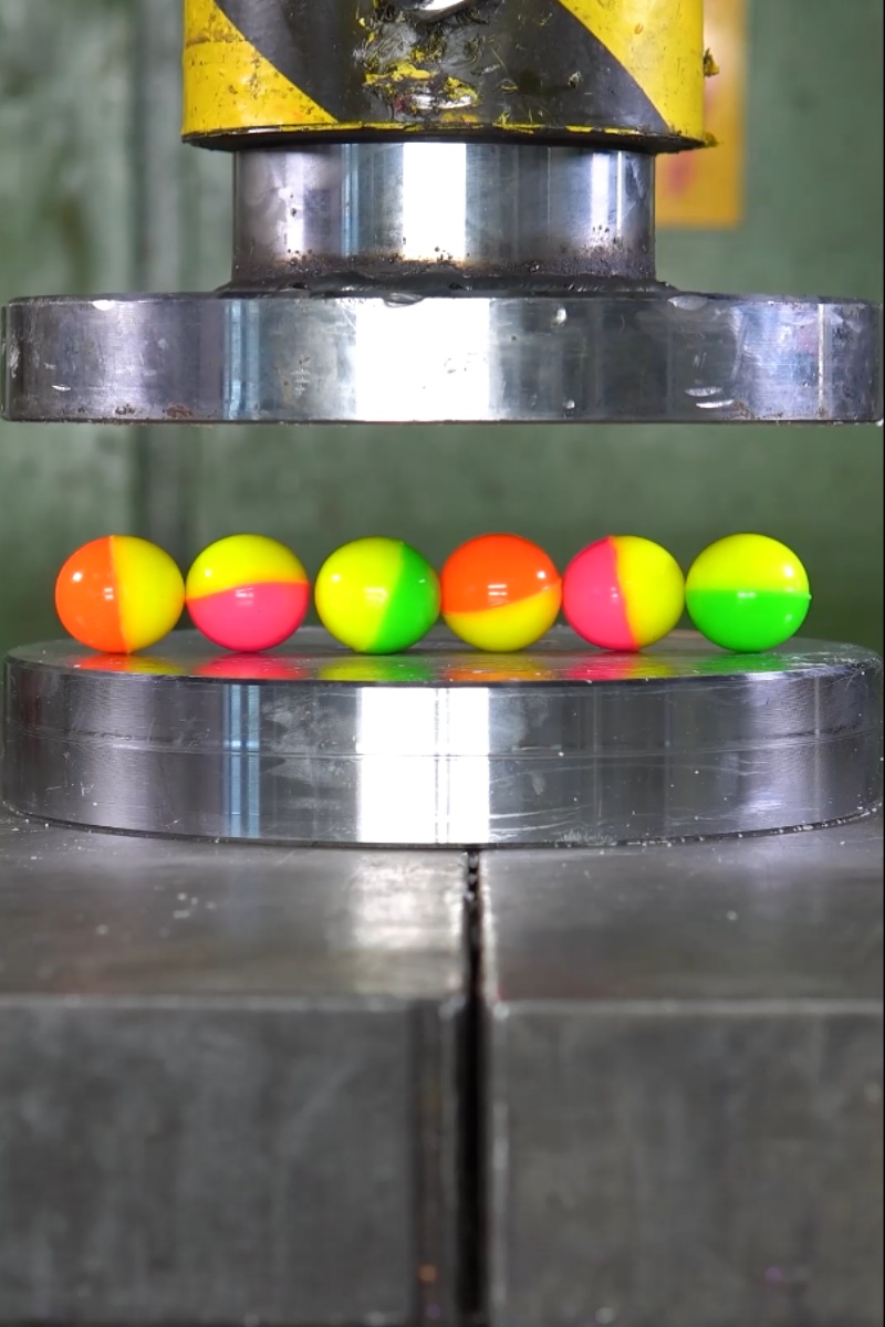 Hydraulic press crushing colorful rubber balls