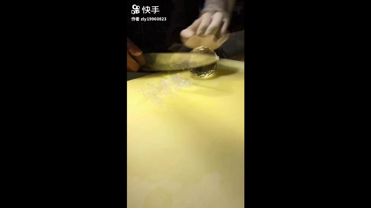 Carving crystal clear ice sphere by hand, creating premium cocktail ice ...