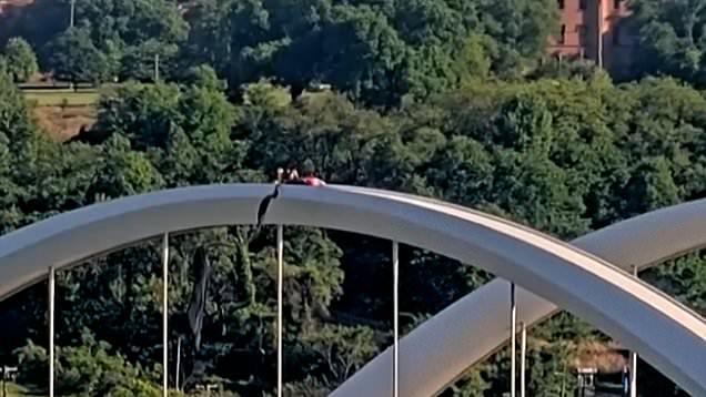 Protestor is seen on top of Frederick Douglass bridge in Washington DC