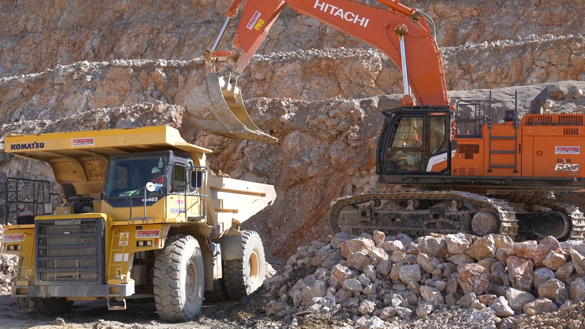 Grote graafmachine en dumptruck aan het werk op een mijnsite