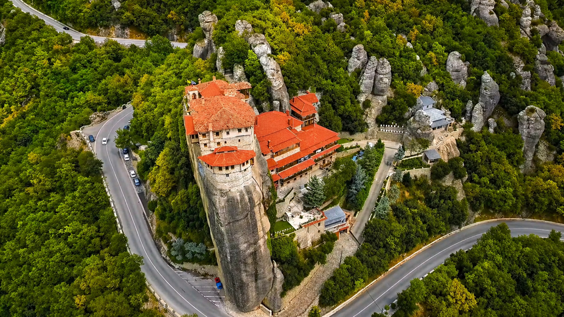 Monasterio de montaña construido sobre una roca vertical con camino sinuoso