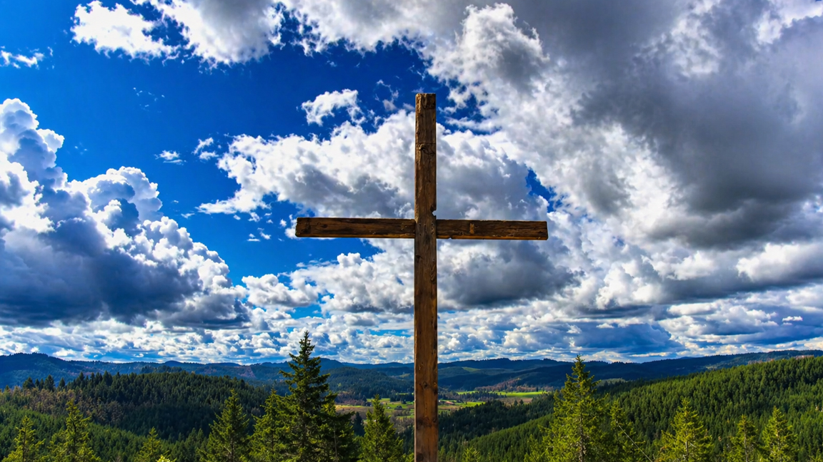 Peaceful hilltop cross with forest and cloudy horizon
