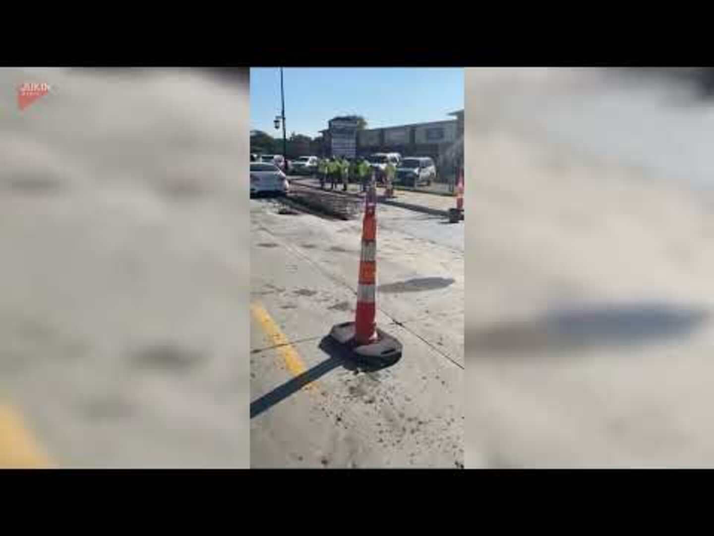Woman drives her car over freshly laid cement on road