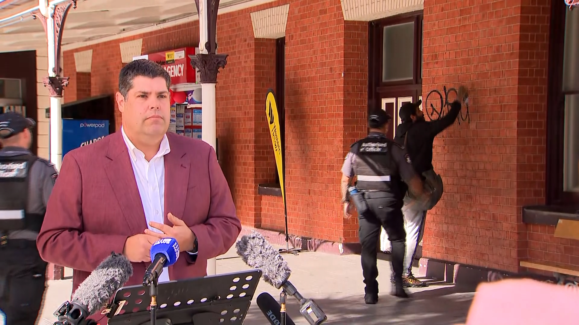 Graffiti protester crashes Queensland transport minister's live press ...