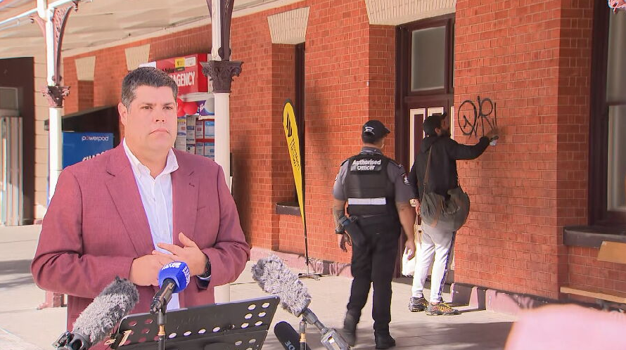 Graffiti protester crashes Queensland transport minister's live press ...