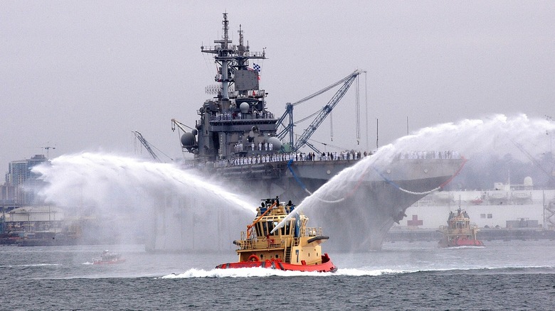 Why do tugboats spray water while towing ships?