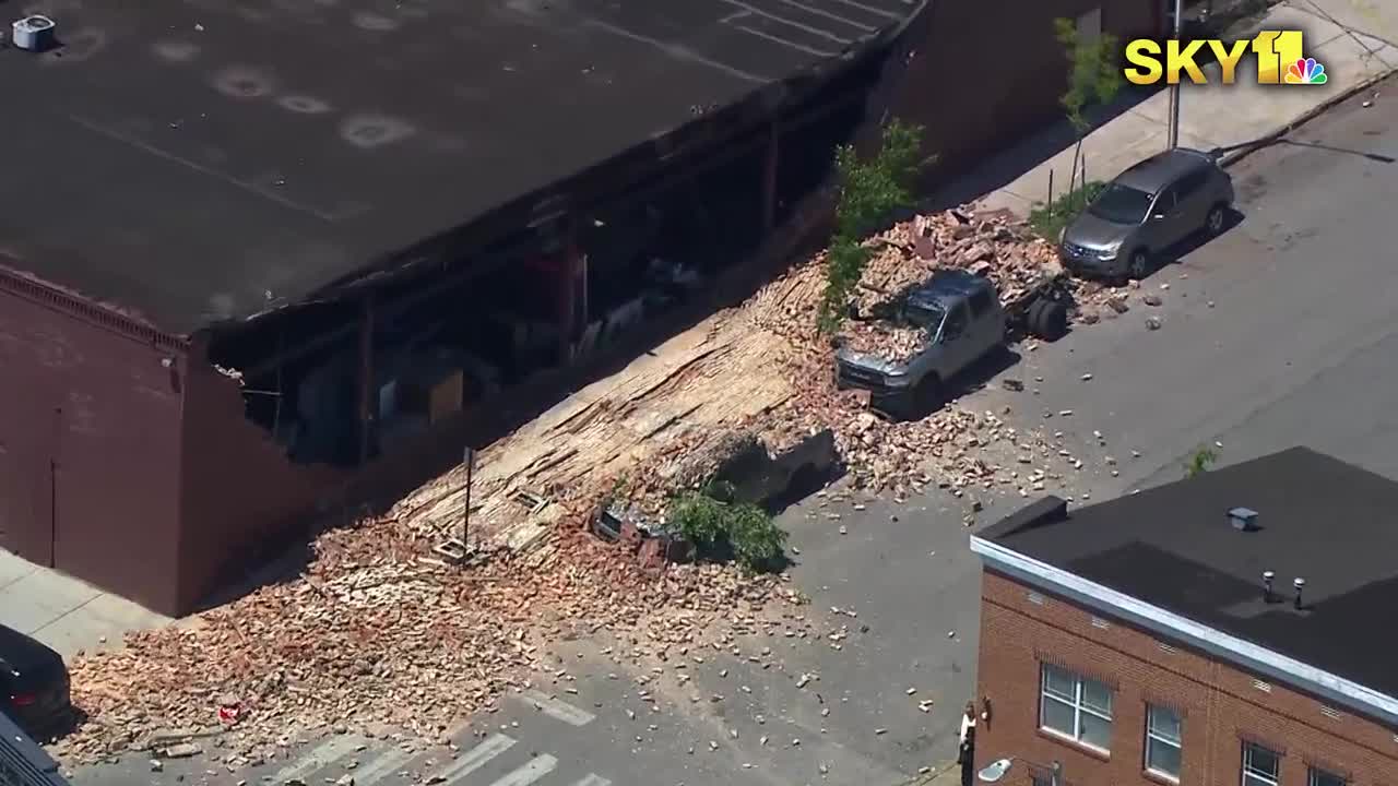 Partial building collapse buries parked cars under bricks