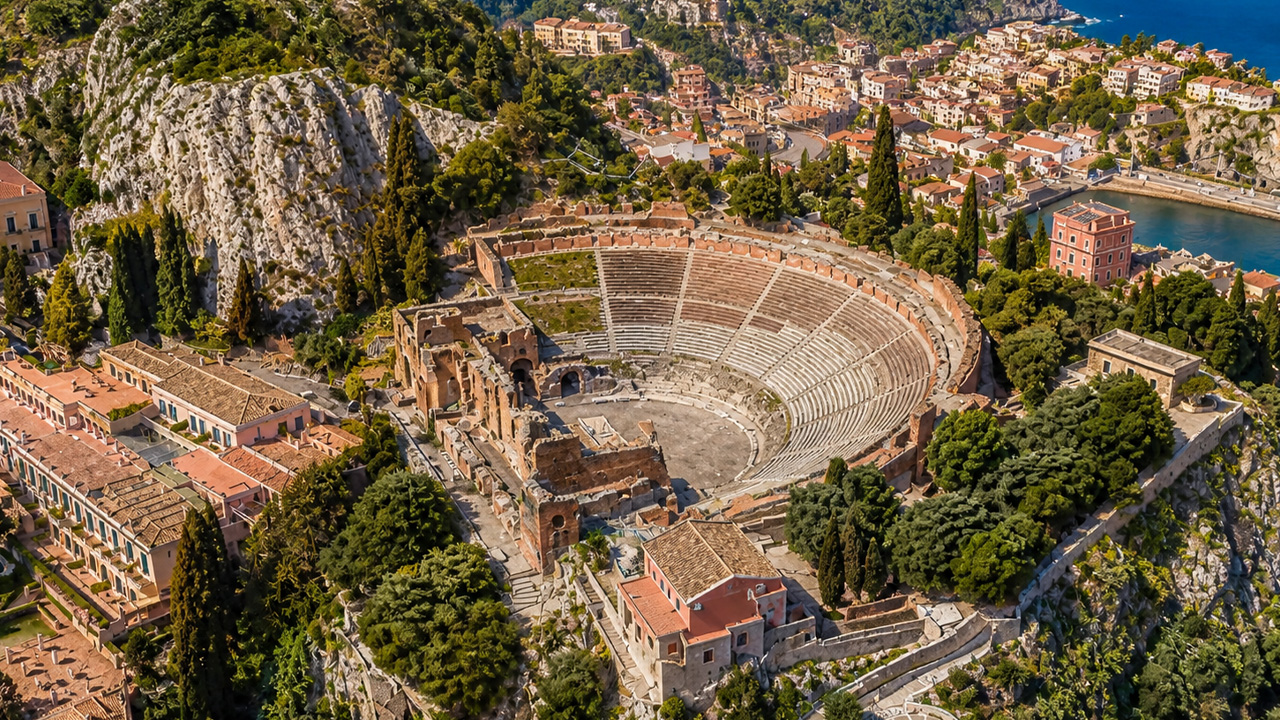 Teatro na encosta de Taormina e cidade costeira vista de cima