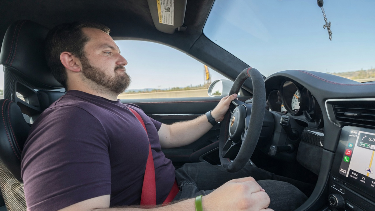The determined face of performance driving inside a Porsche GT3