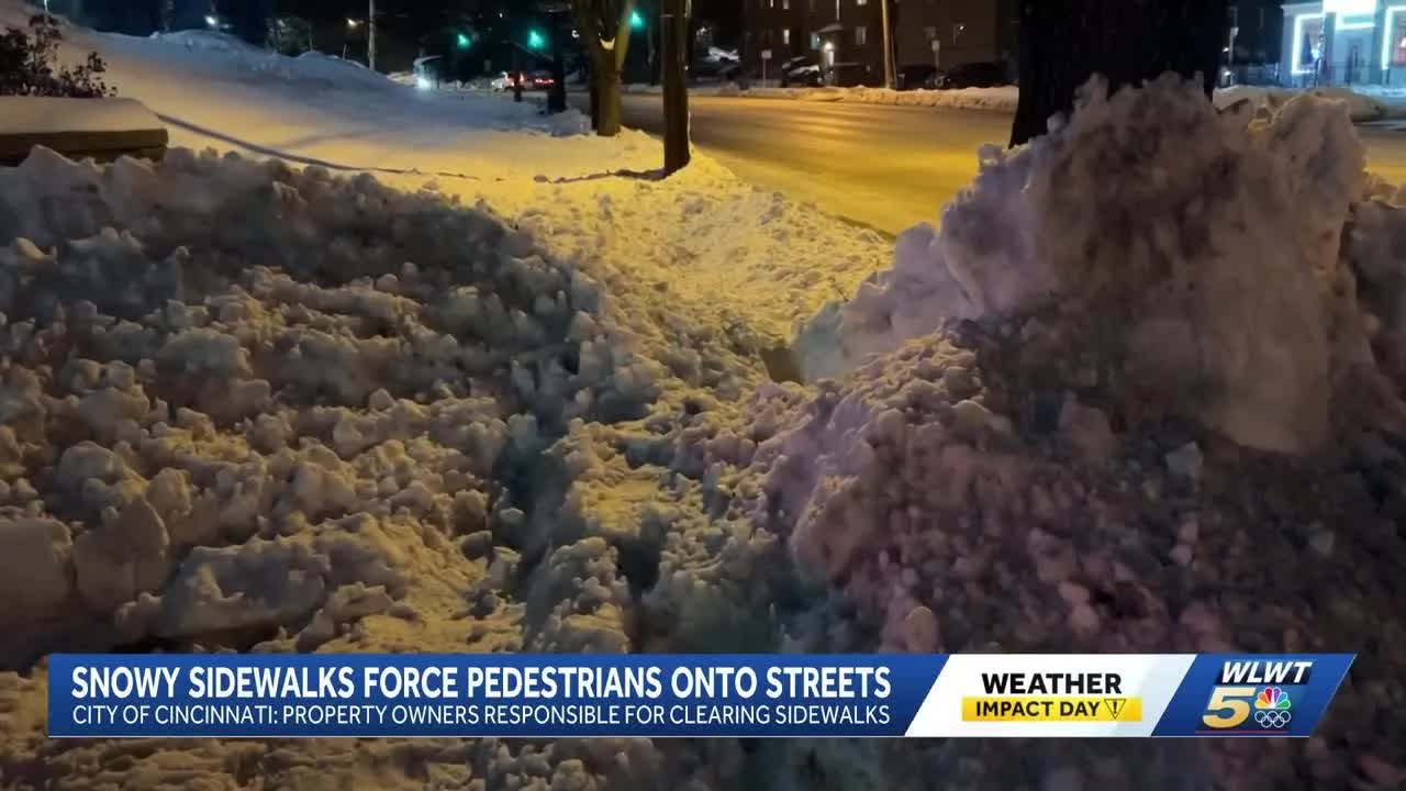Pedestrians forced to walk in street due to snowy sidewalks