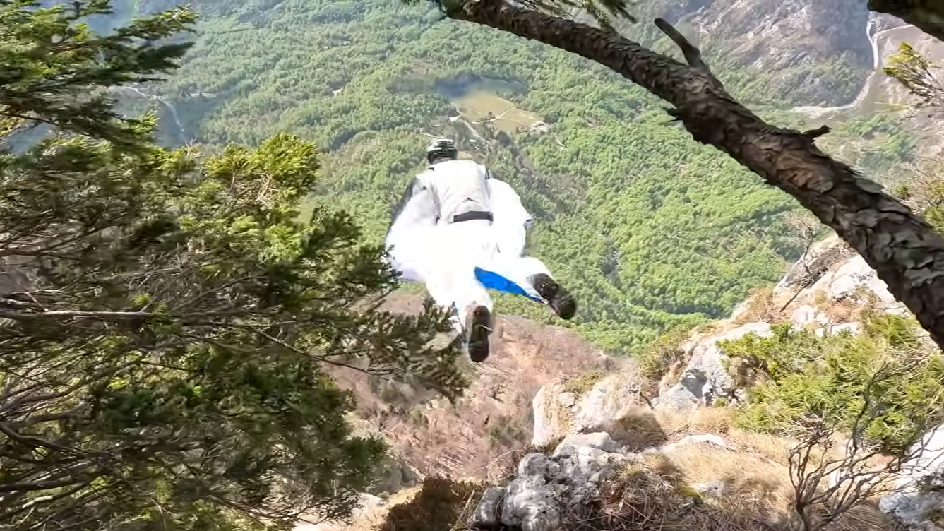 Man jumps from a cliff into a dense forest
