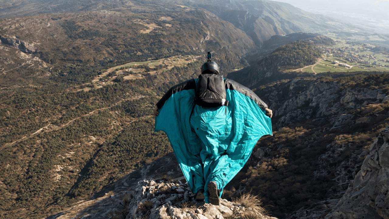 Man jumps from a beautiful mountain peak