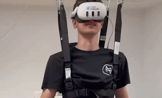 Man with spinal cord injury walks on the beach with VR headset and robot