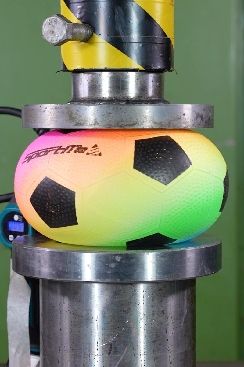 Crushing a rainbow soccer ball under a hydraulic press