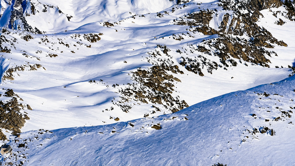 Panoramic snowy mountain scene under bright sunlight