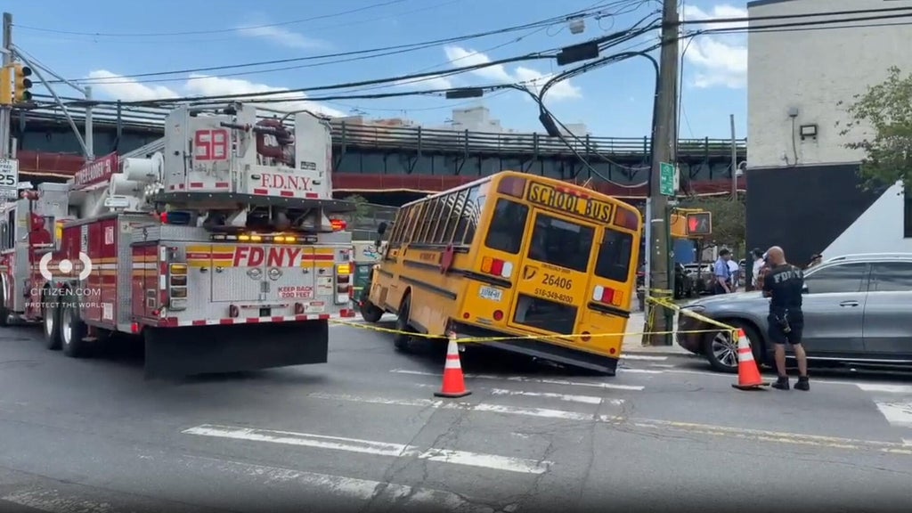 School bus in the Bronx partially trapped in a hole