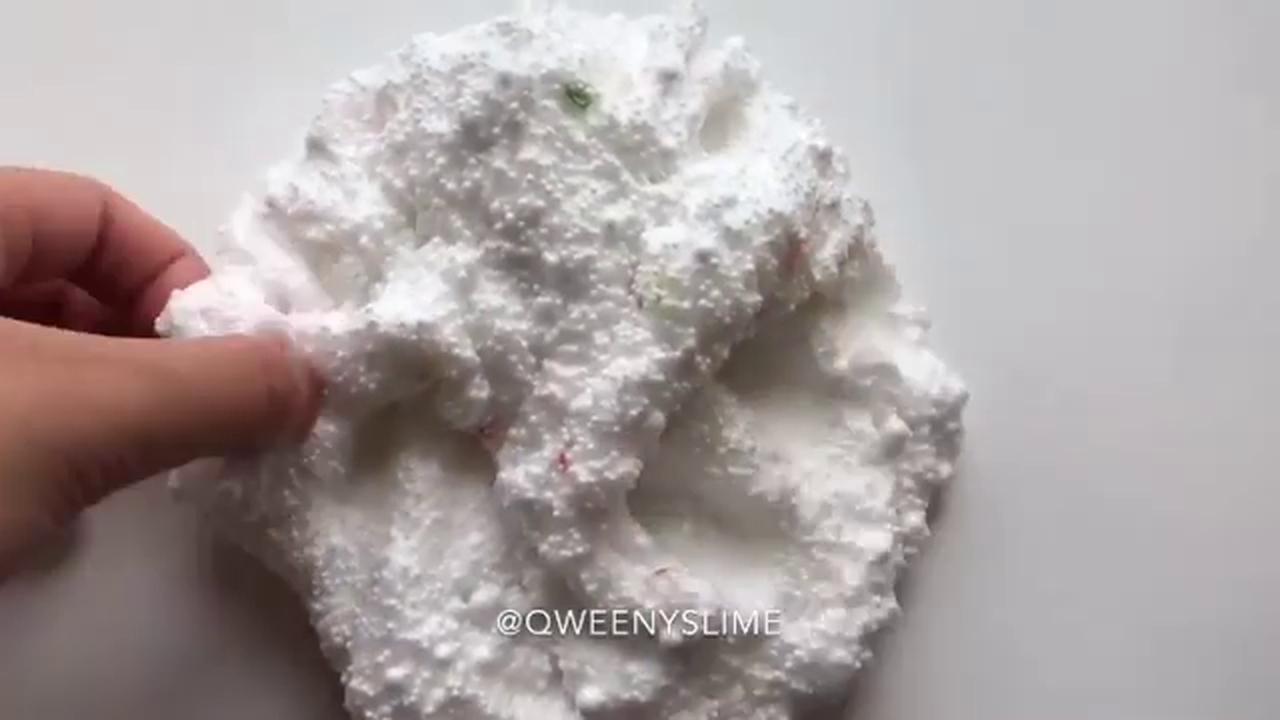 Poking and stretching white foam bead slime creating crunchy snow texture