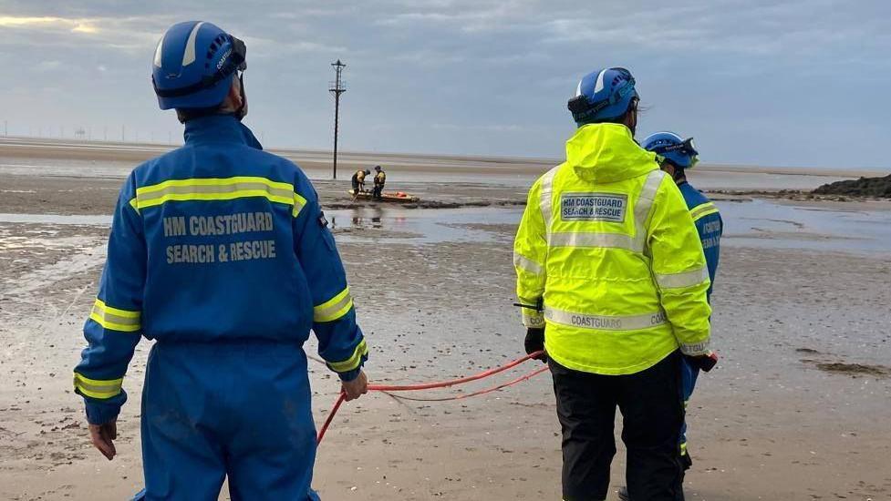 Man and his dog rescued after getting stuck in mud