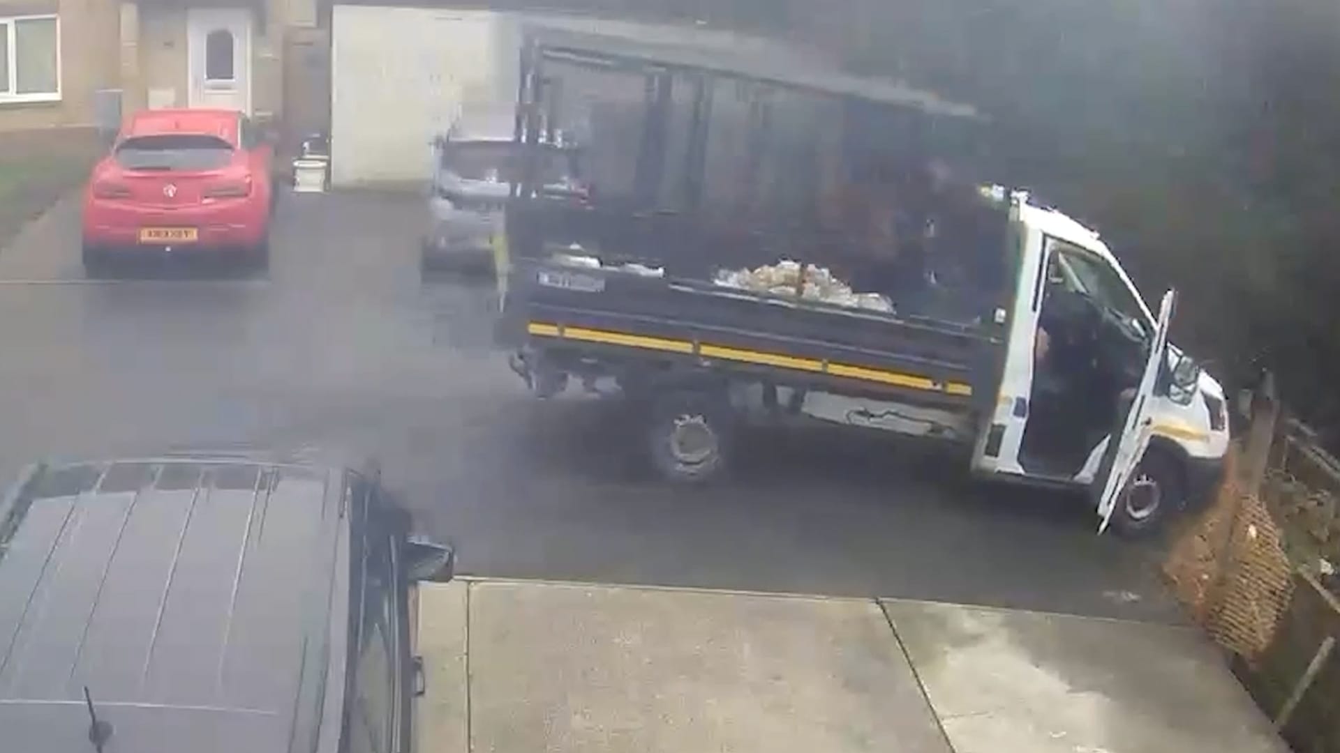 Garbage truck crashes through fence and tumbles down bank