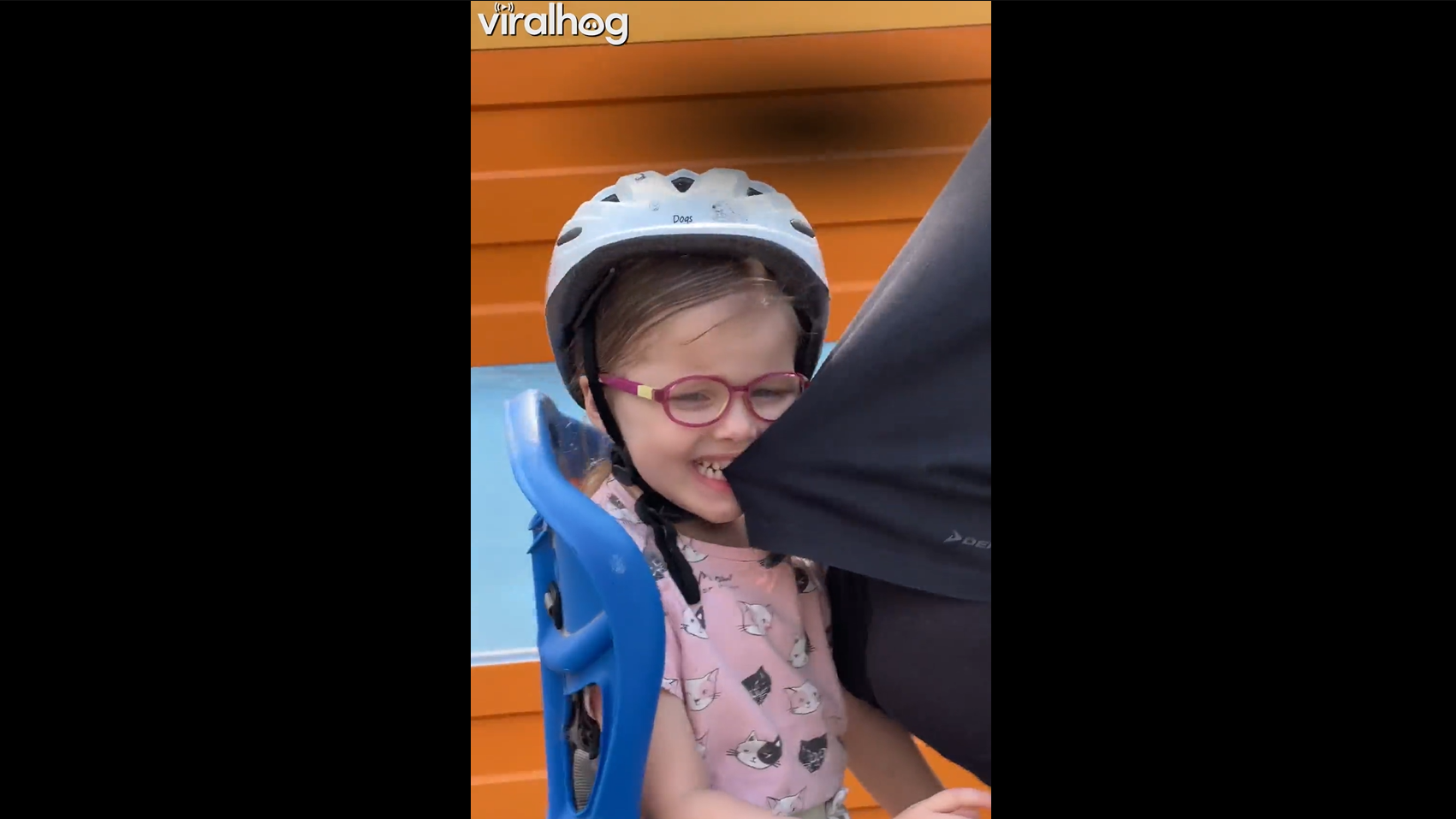 Girl on bike biting dad