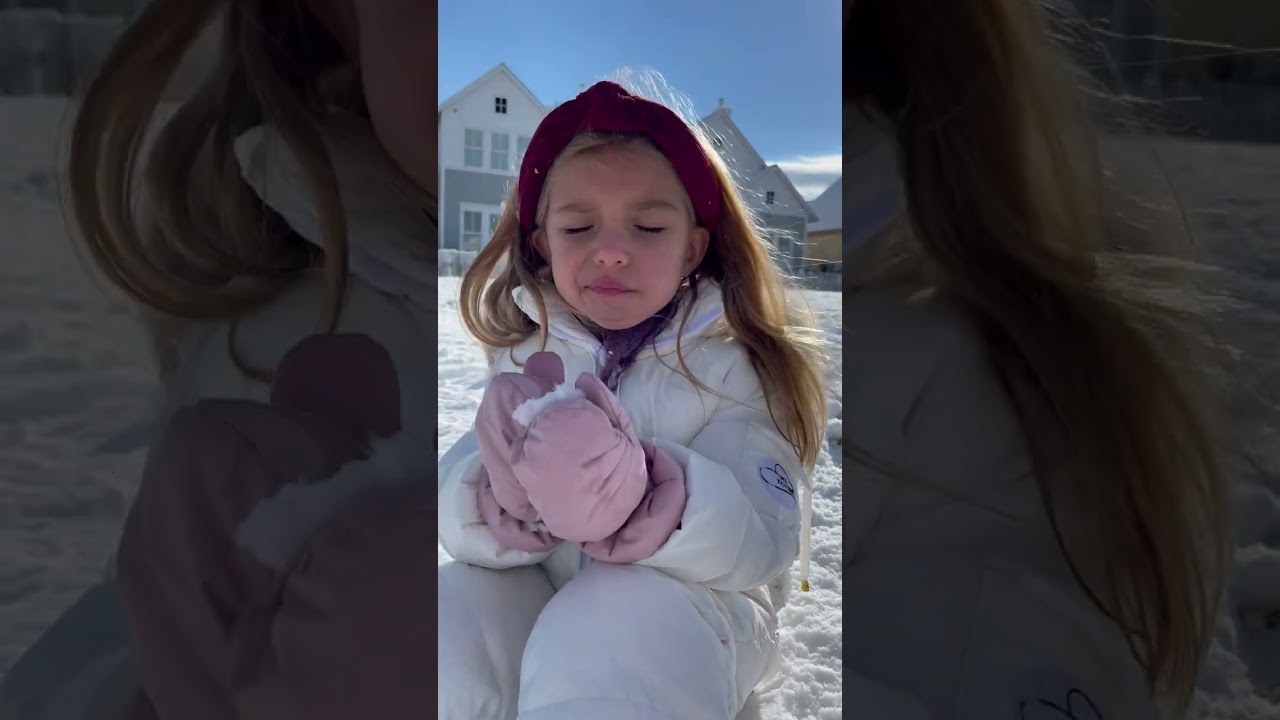 Toddler enjoys an unusual and chilly outdoor picnic in snow