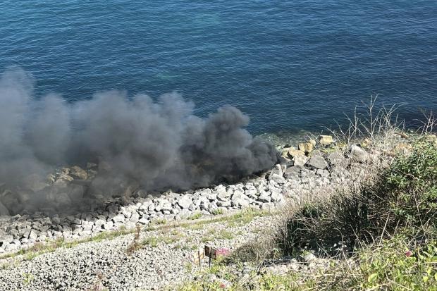 Person rescued from sea as boat crashes ashore and bursts into flames