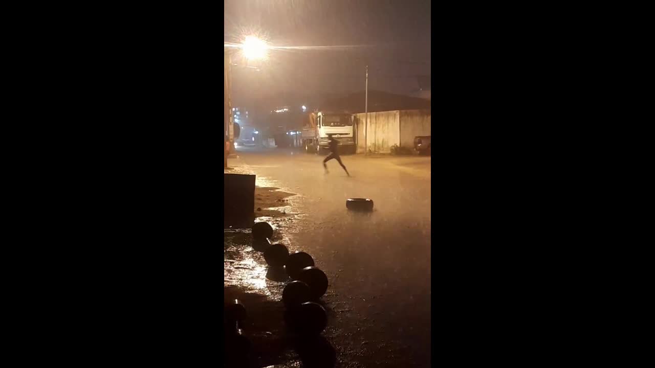 Man shadow boxes in heavy rain in France