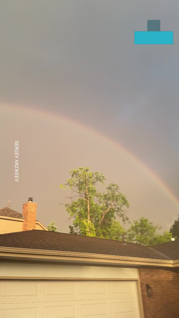 Lightning storm illuminates sky over rainbow in Nebraska