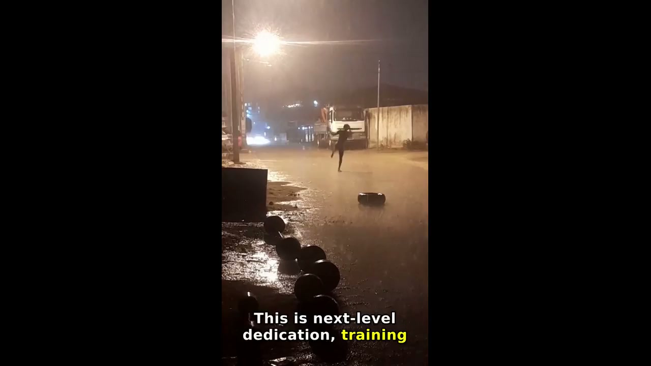 Man shadow boxes fiercely in pouring rain