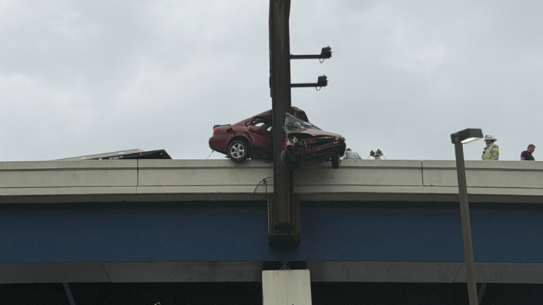 Police: Driver 'fine' after crash sends car hanging off side of ...