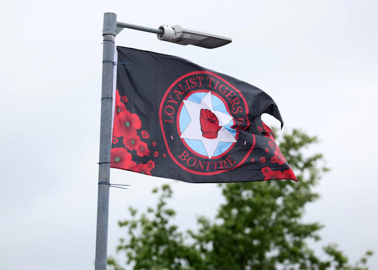 UDA and bonfire flags erected near contentious north Belfast pyre