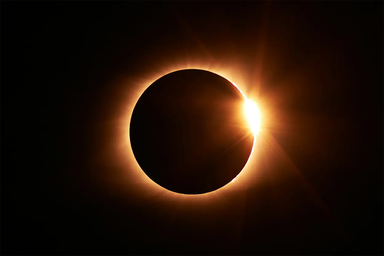 En la playa a los pies de un castillo templario mientras ves un eclipse ...