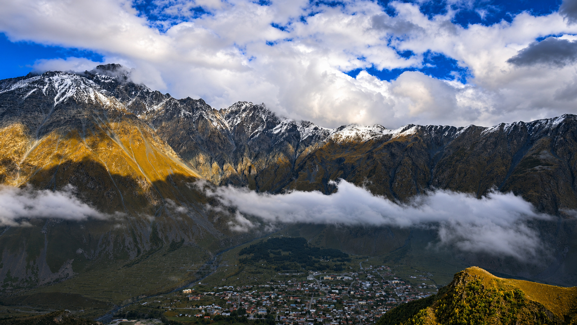 Majestic snow capped mountains above cloudy valley