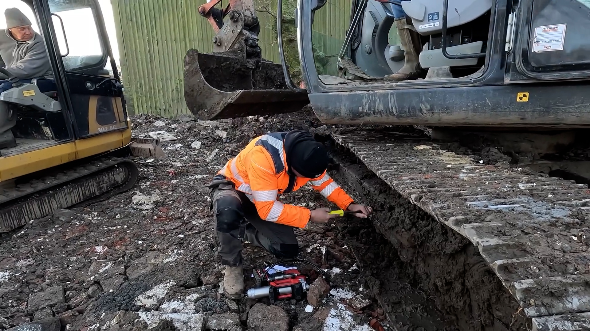 Excavator track repair on muddy construction site