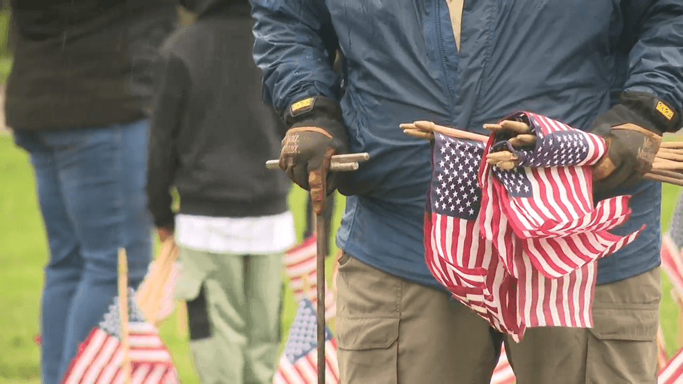 Volunteers place thousands of flags on graves of veterans at Fort ...