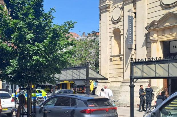 Police officers talk with group of men outside city bar
