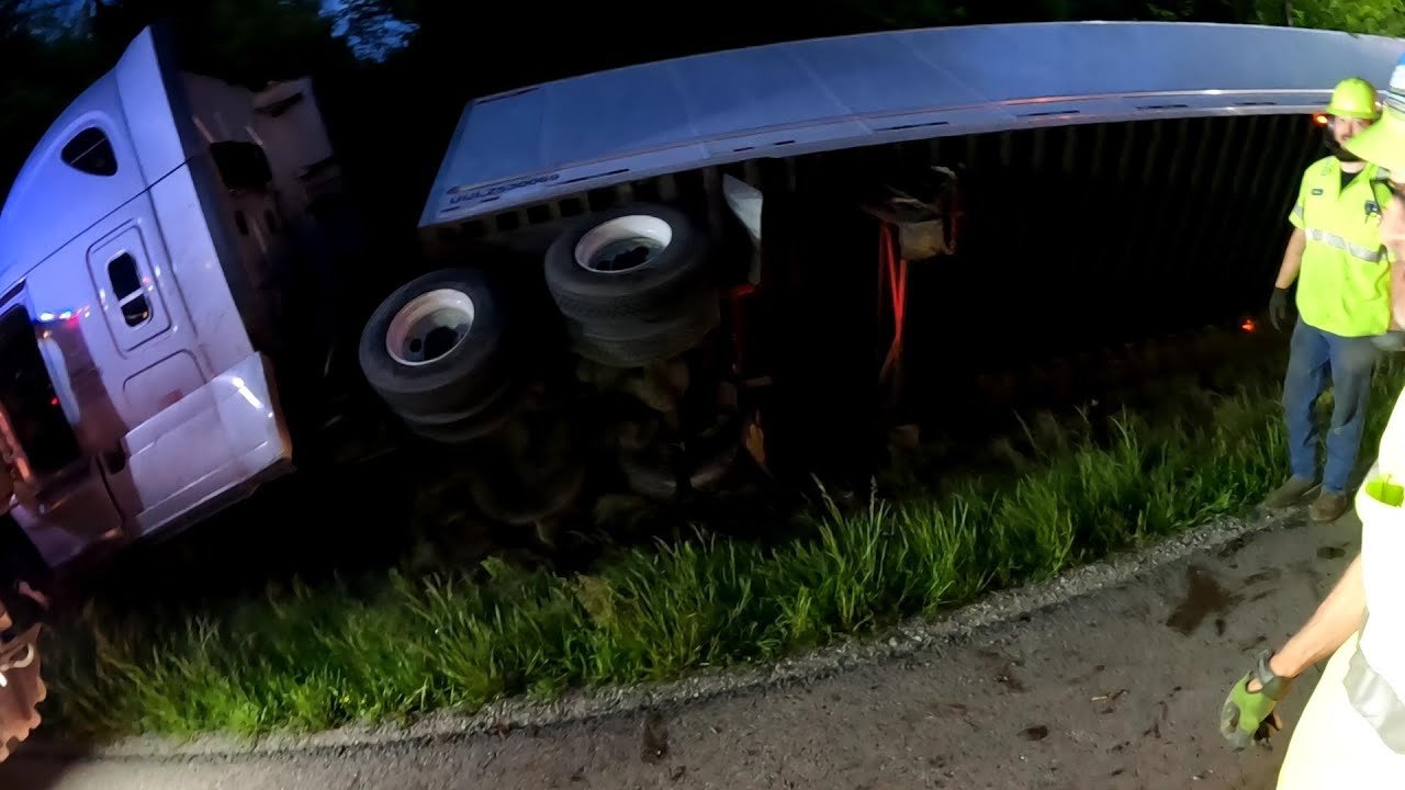 Log truck flips on a two-lane road