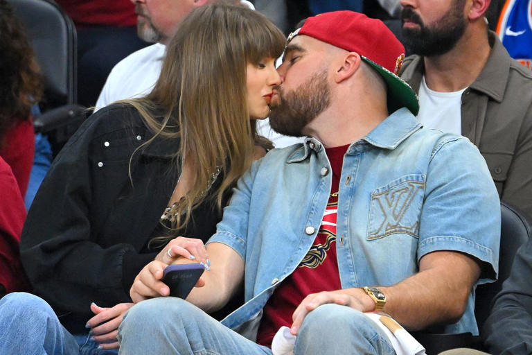 Taylor Swift hides her face as fiancé Travis Kelce chugs a beer during ...