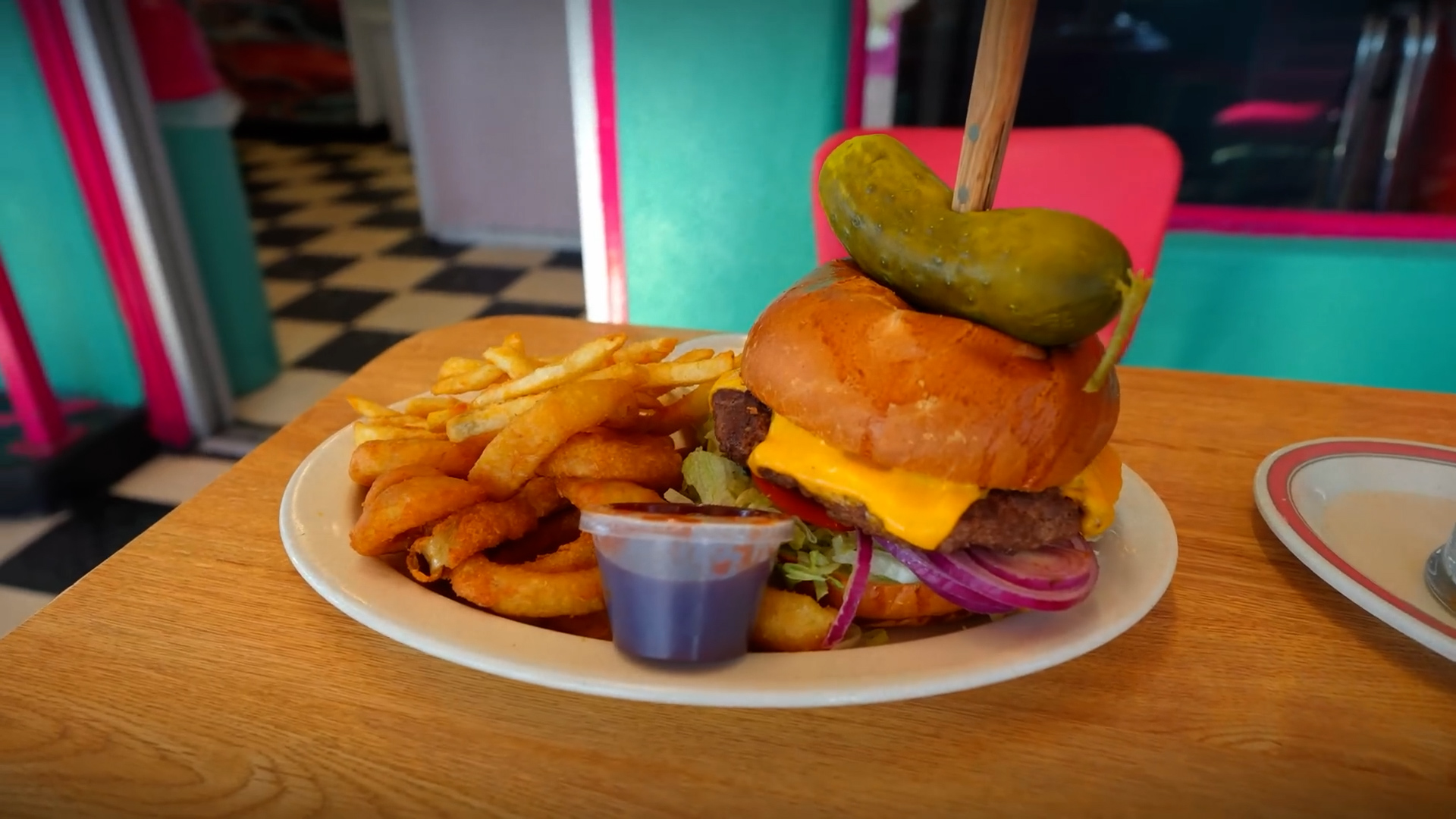Man attempts giant diner burger challenge with oversized pickle and fries
