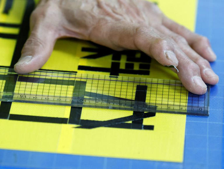 Japanese security guard finds fame as designer of duct tape signs
