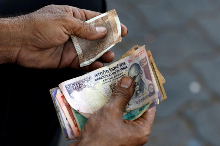 Rupee gains to two-week high, forward premiums dip as oil prices slump