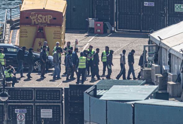 Migrant mayhem as asylum seekers wade through water for 'taxi boat' to ...