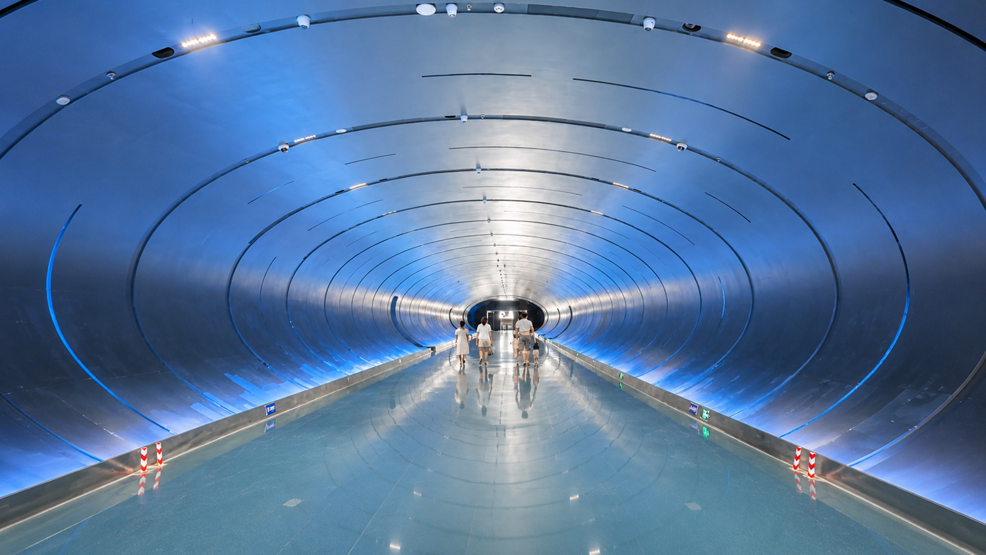 Een gebogen metalen tunnel verbindt moderne publieke binnenruimtes in China